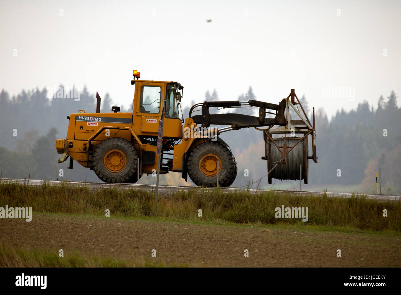 Yellow Wheel loader on a highway Stock Photo - Alamy