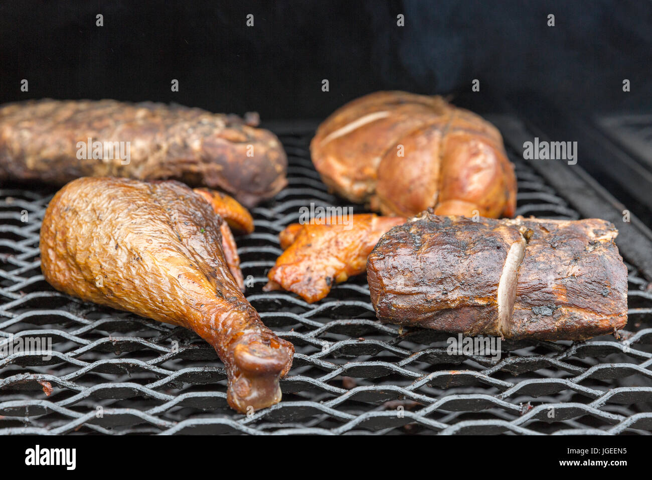 Smoked turkey legs and ham closeup outdoors in smokehouse, street food ...
