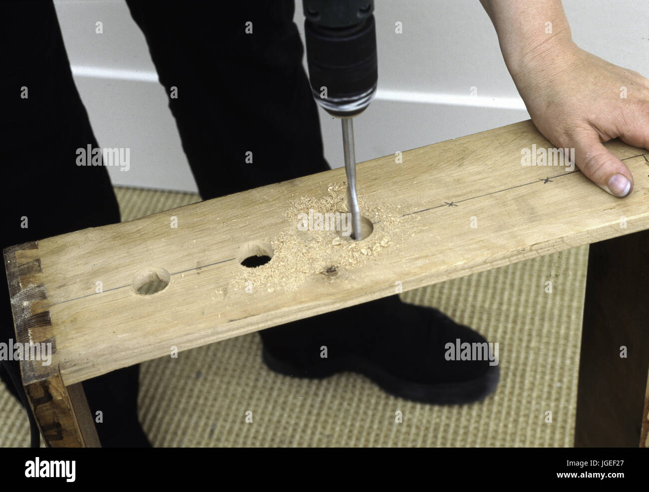 Drilling holes in wooden frame. Making a suspended storage rack. Step x ...
