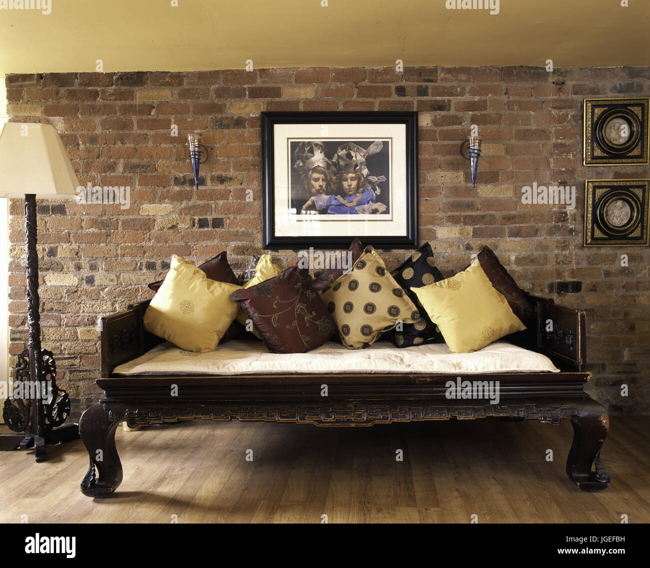 Antique wooden seating against brick wall in renovated flat Stock Photo ...