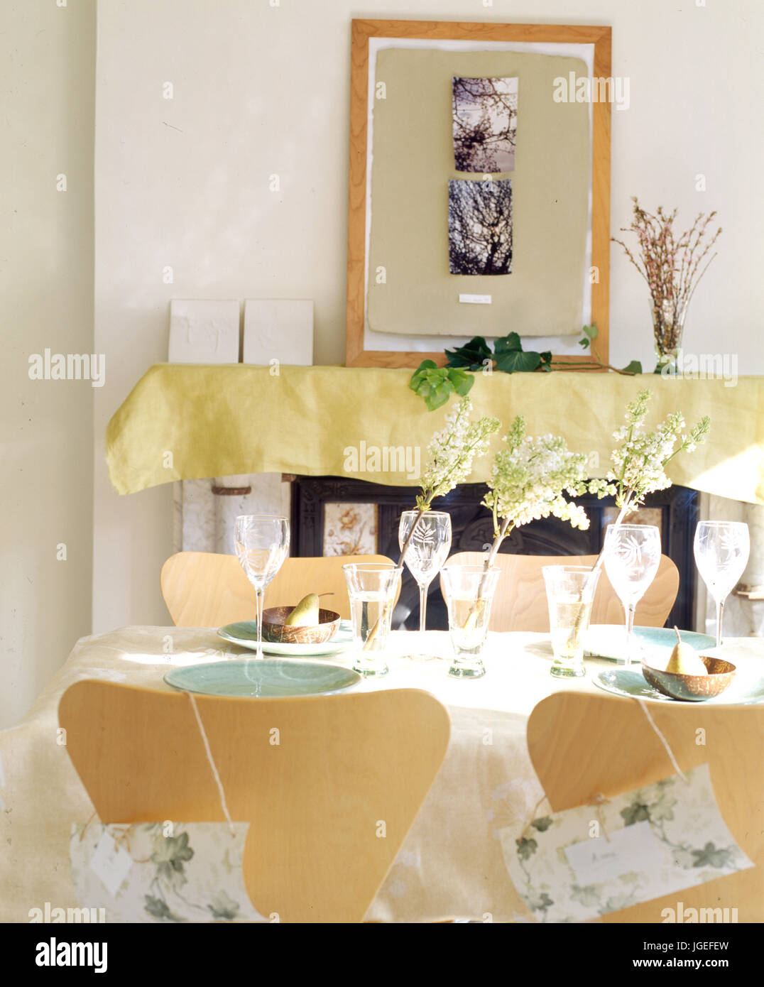 Framed photographs above mantlepiece with pale yellow linen cloth Stock ...