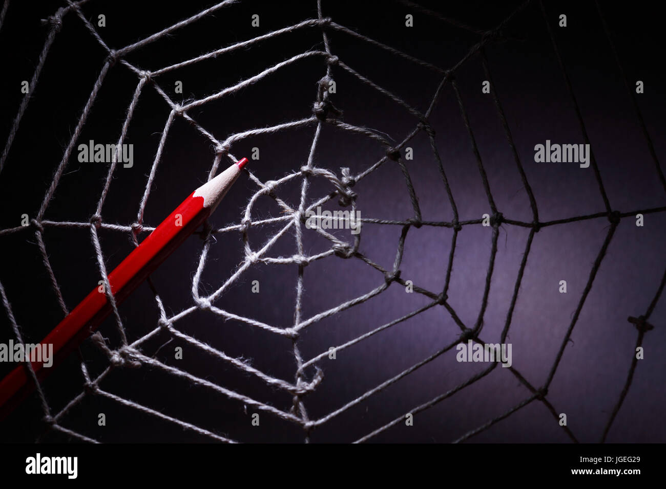 Web design concept. Red pencil in rope web on dark background Stock ...