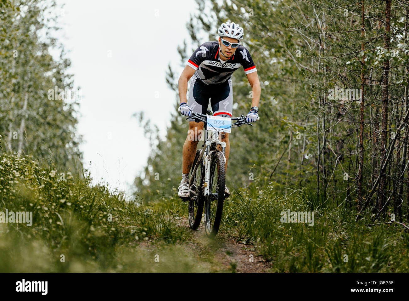 young male cyclist riding along a forest trail during Regional ...