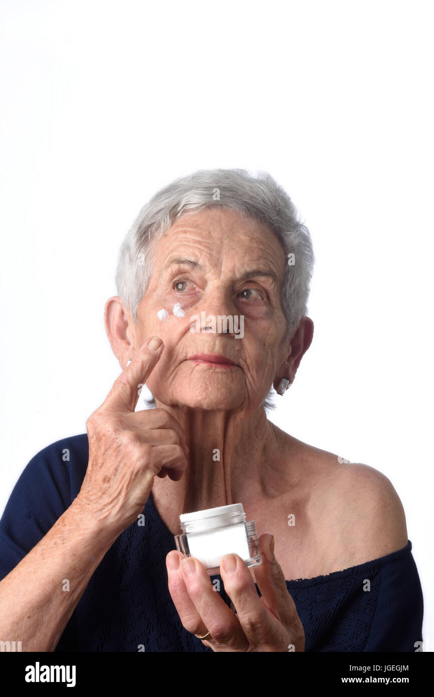 Senior woman applying skin cream or moisturiser to her face Stock Photo ...