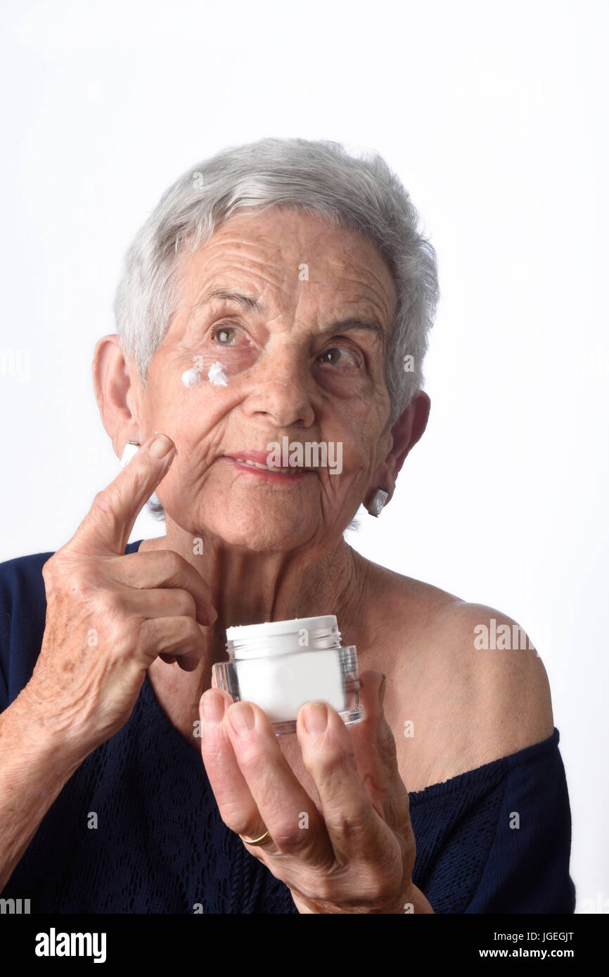 Senior woman applying skin cream or moisturiser to her face Stock Photo ...