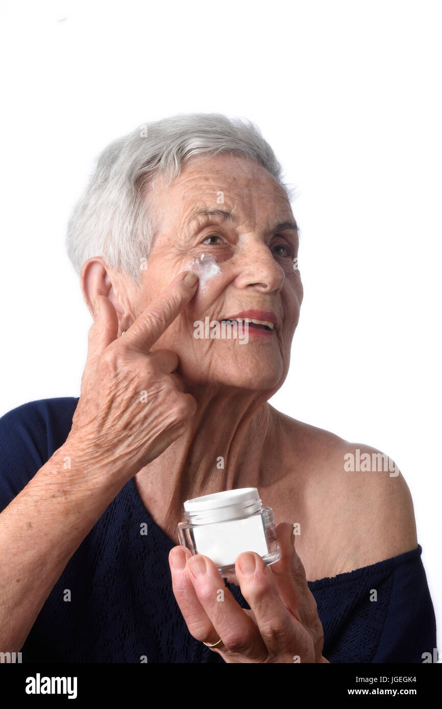 Senior woman applying skin cream or moisturiser to her face Stock Photo ...