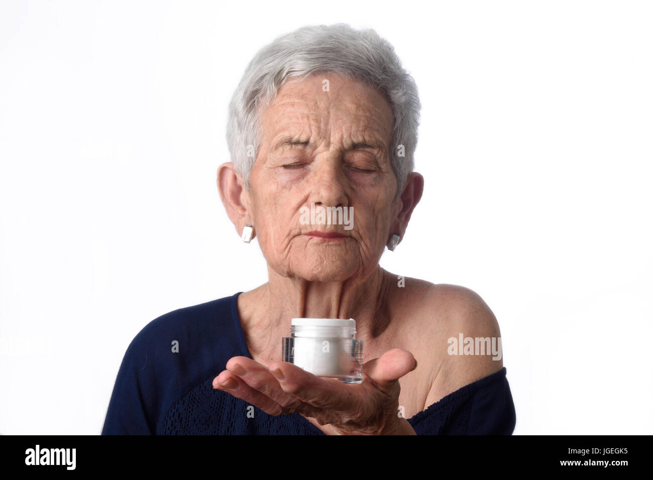Senior woman applying skin cream or moisturiser to her face Stock Photo ...
