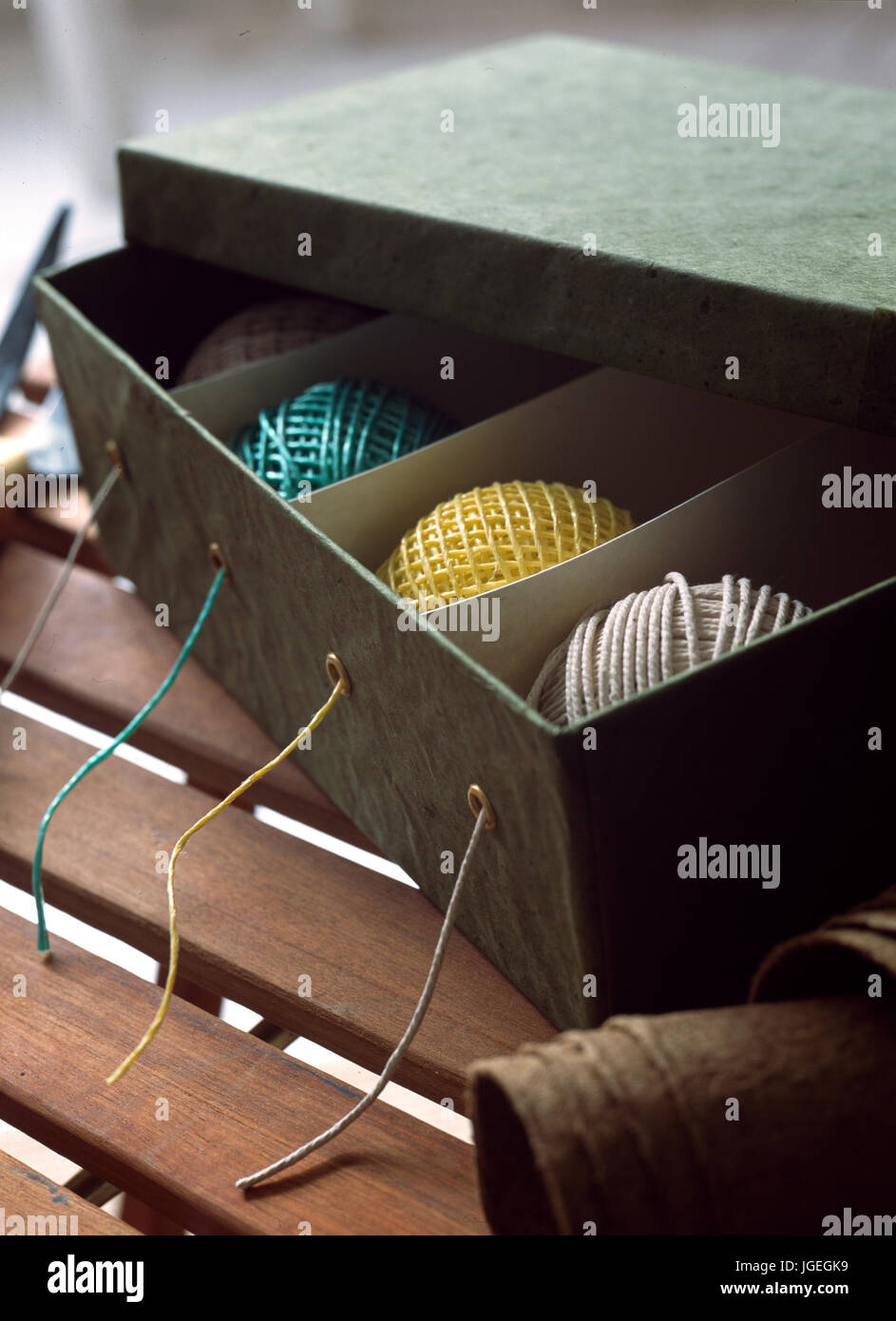 Balls of coloured strings in box customised to hold string. Step x step ...