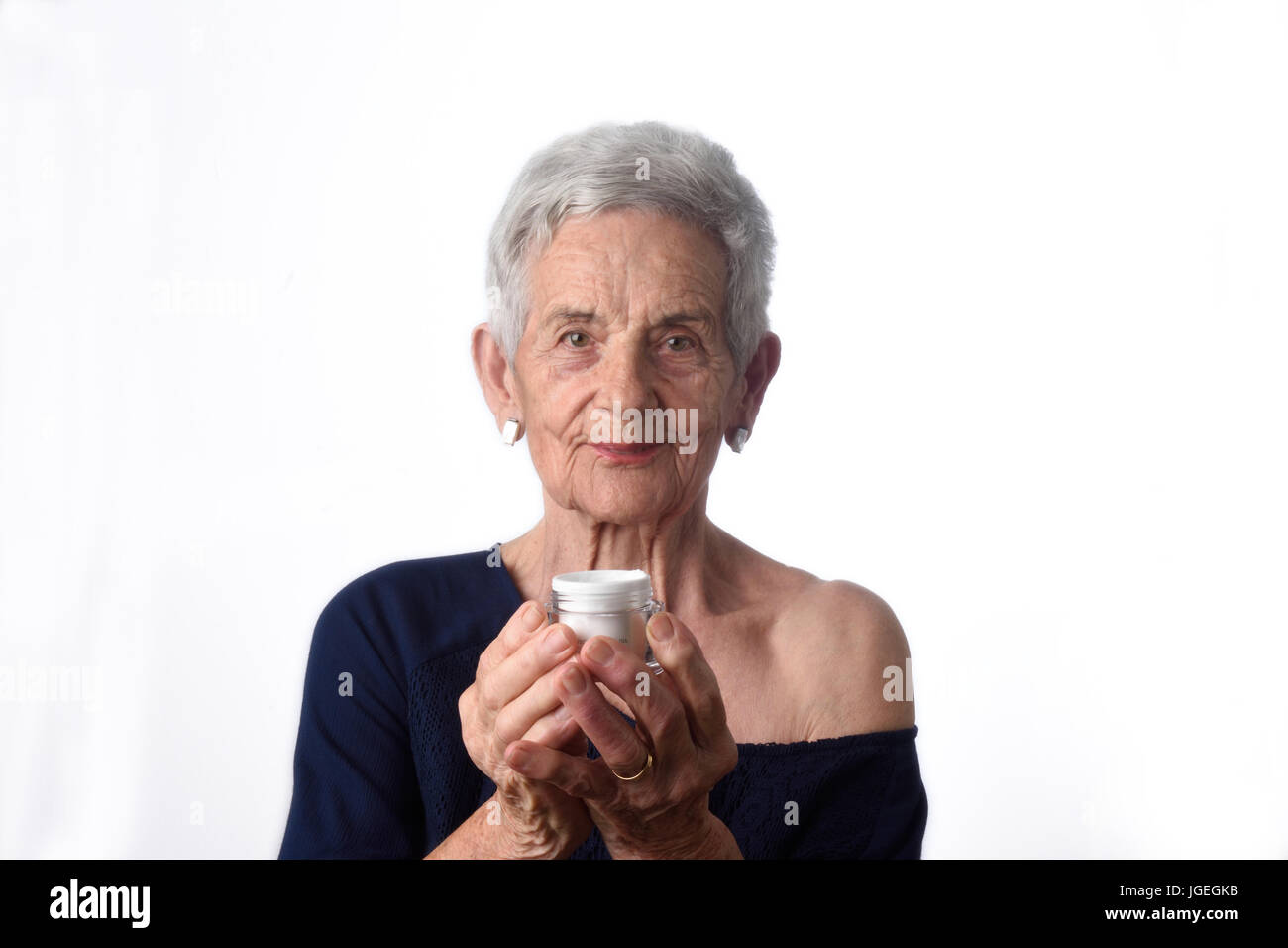 Senior woman applying skin cream or moisturiser to her face Stock Photo ...