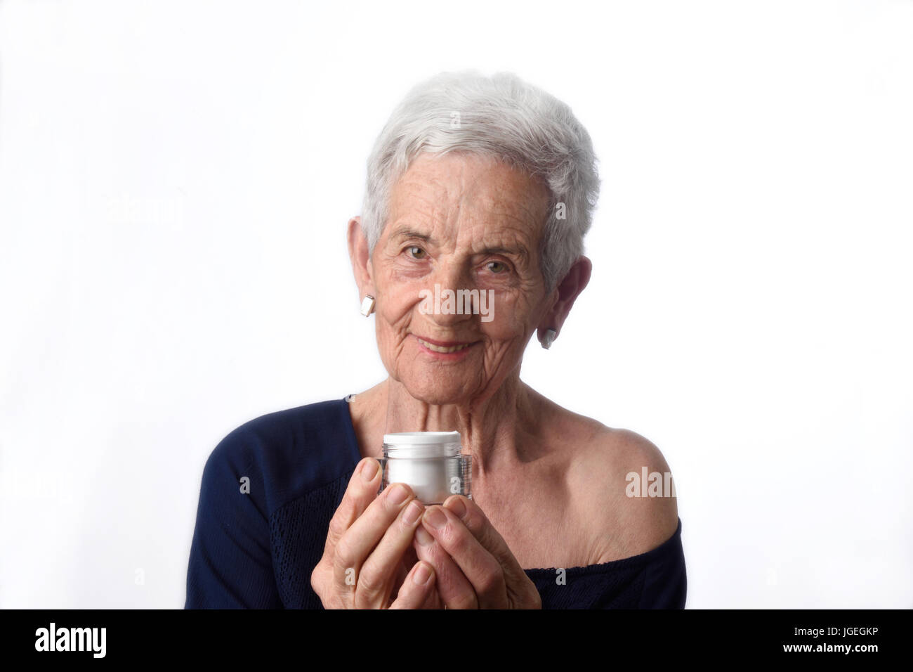 Senior woman applying skin cream or moisturiser to her face Stock Photo ...