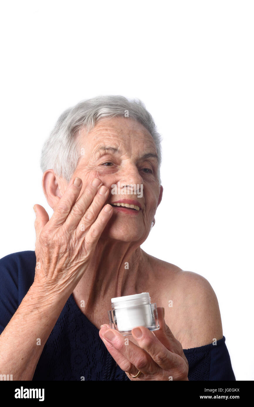Senior woman applying skin cream or moisturiser to her face Stock Photo ...