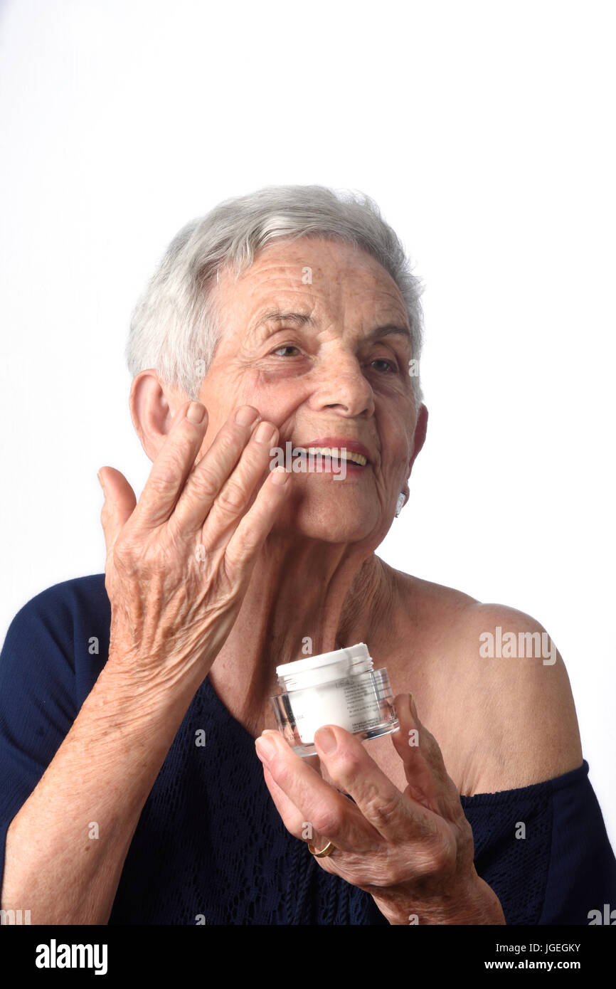 Senior woman applying skin cream or moisturiser to her face Stock Photo ...