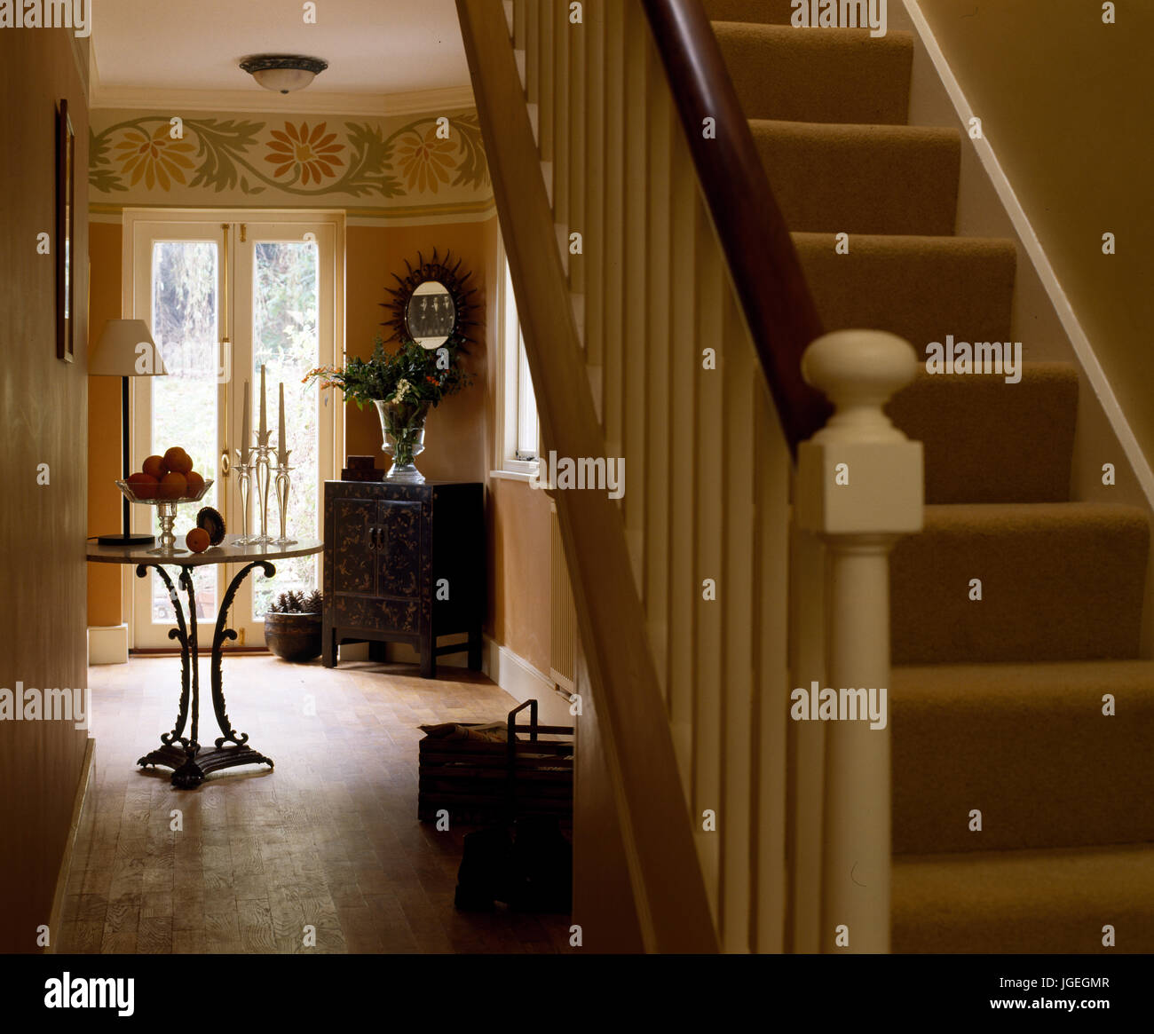 Staircase leading out of open plan hallway with hand-painted frieze ...