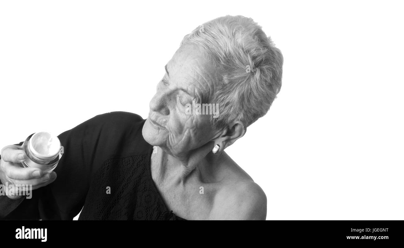 Senior woman applying skin cream or moisturiser to her face Stock Photo ...