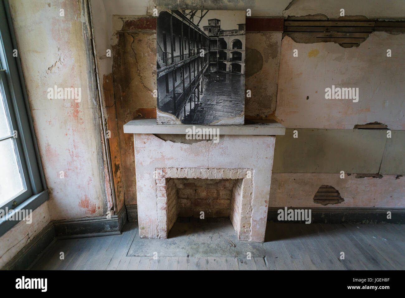 Old fireplace in abandoned building with old photo and peeling paint ...