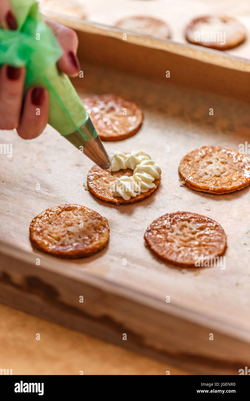 Woman hand decorating mille-feuille cake with pastry cream Stock Photo ...