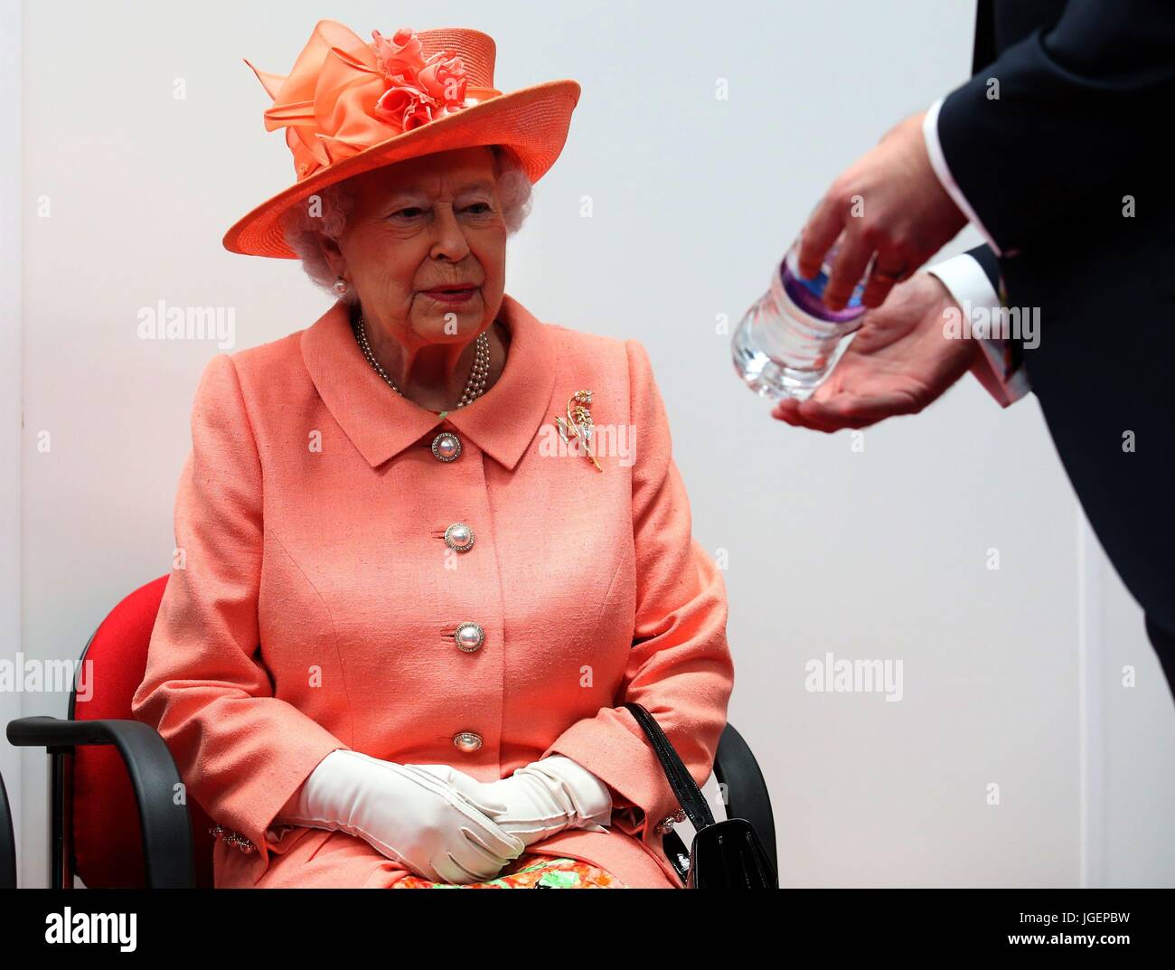 Queen Elizabeth II is shown a bottle of Highland Spring with her name ...