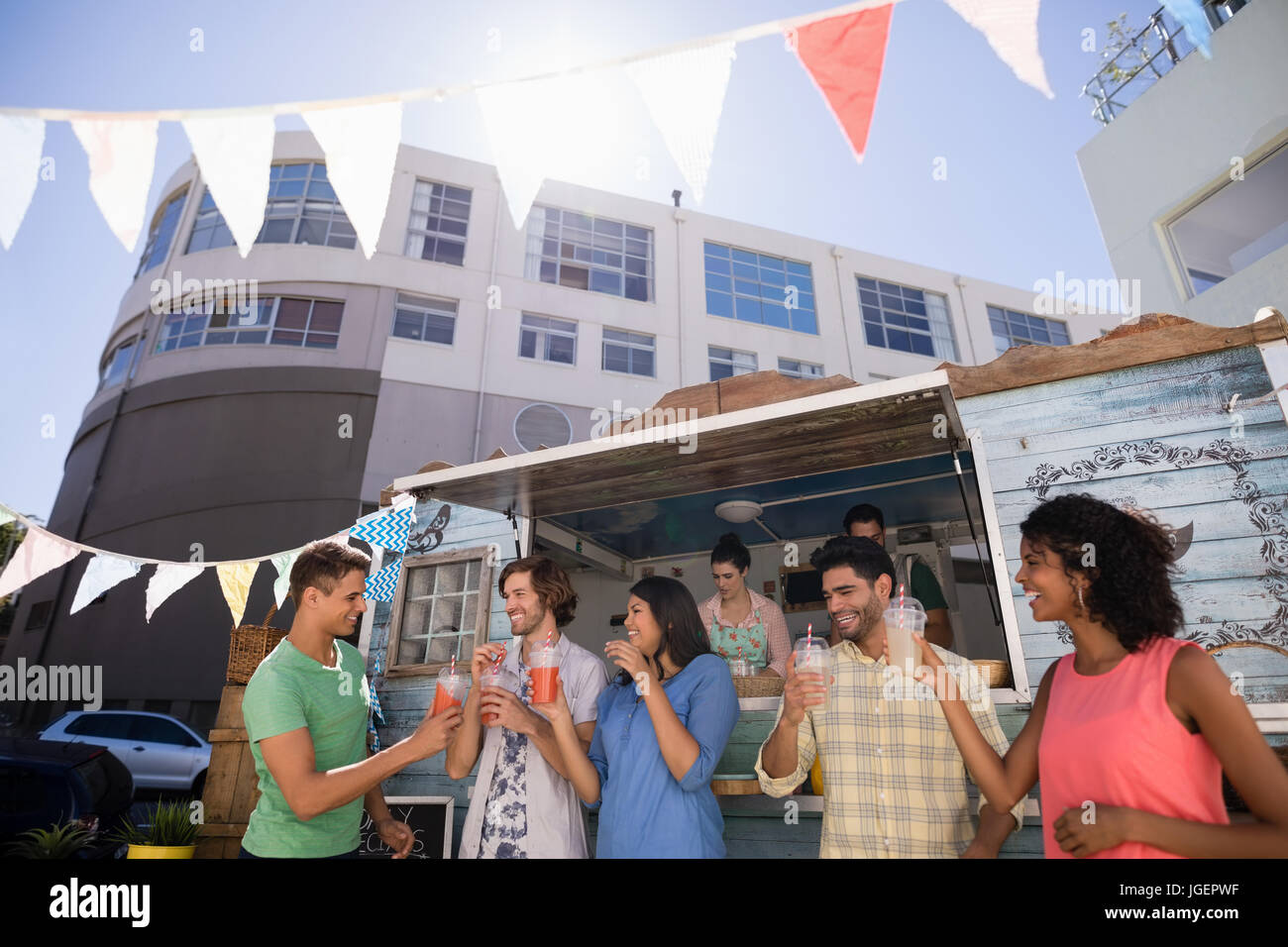 Smiling friends interacting while having juice Stock Photo - Alamy
