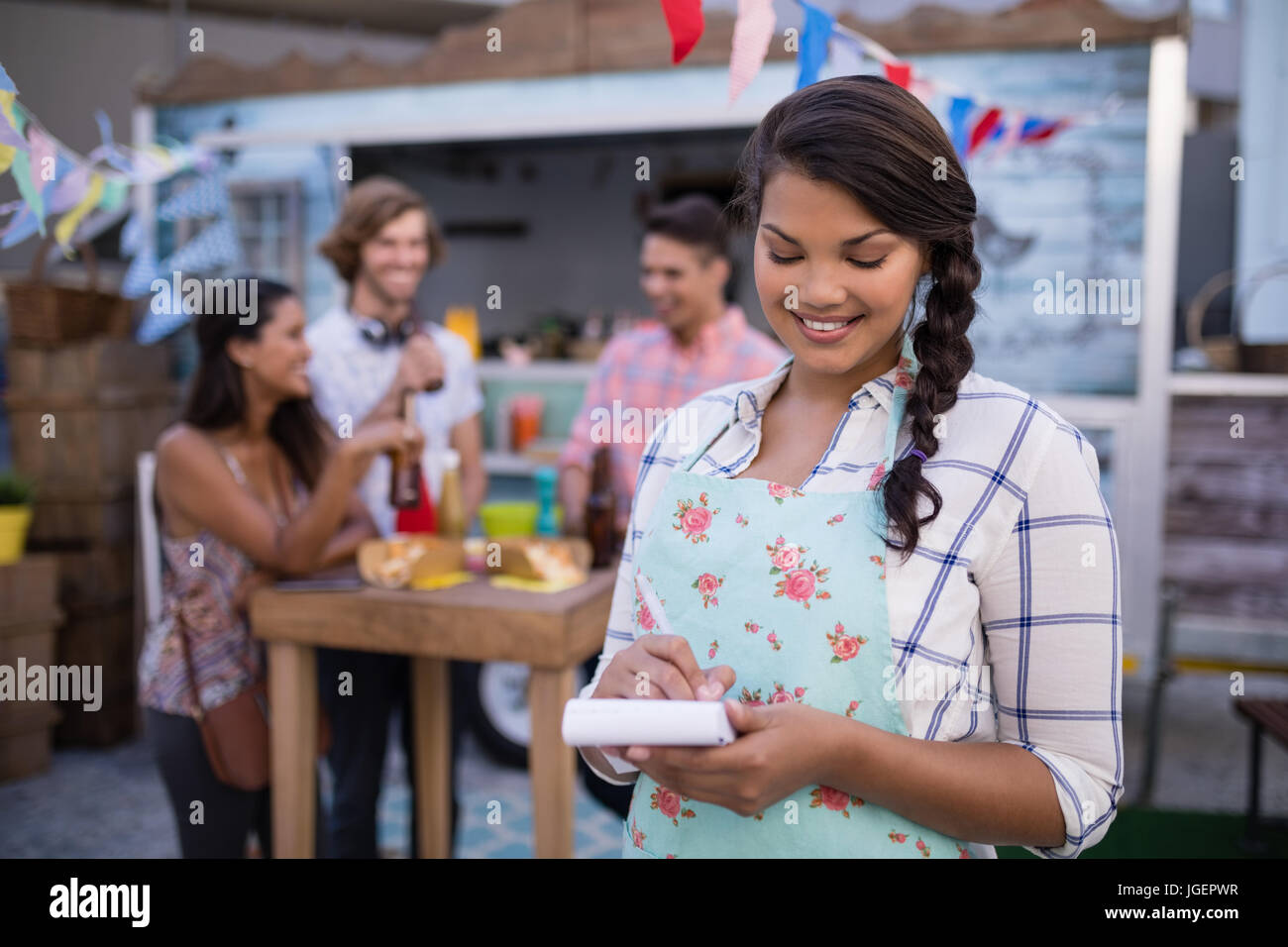 Happy waitress writing order in notepad at cafeteria Stock Photo - Alamy