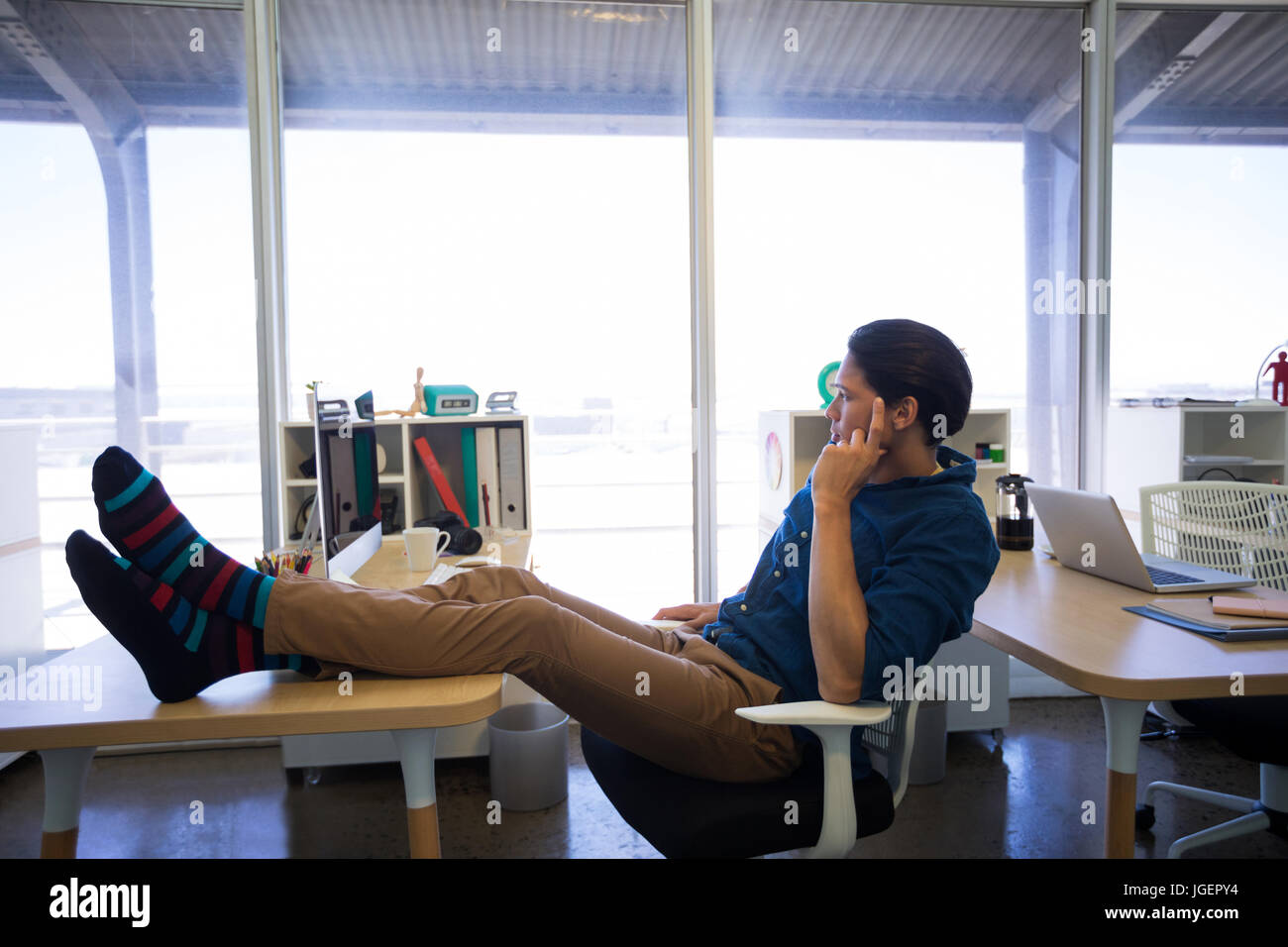 Thoughtful male executive relaxing at his desk in office Stock Photo ...