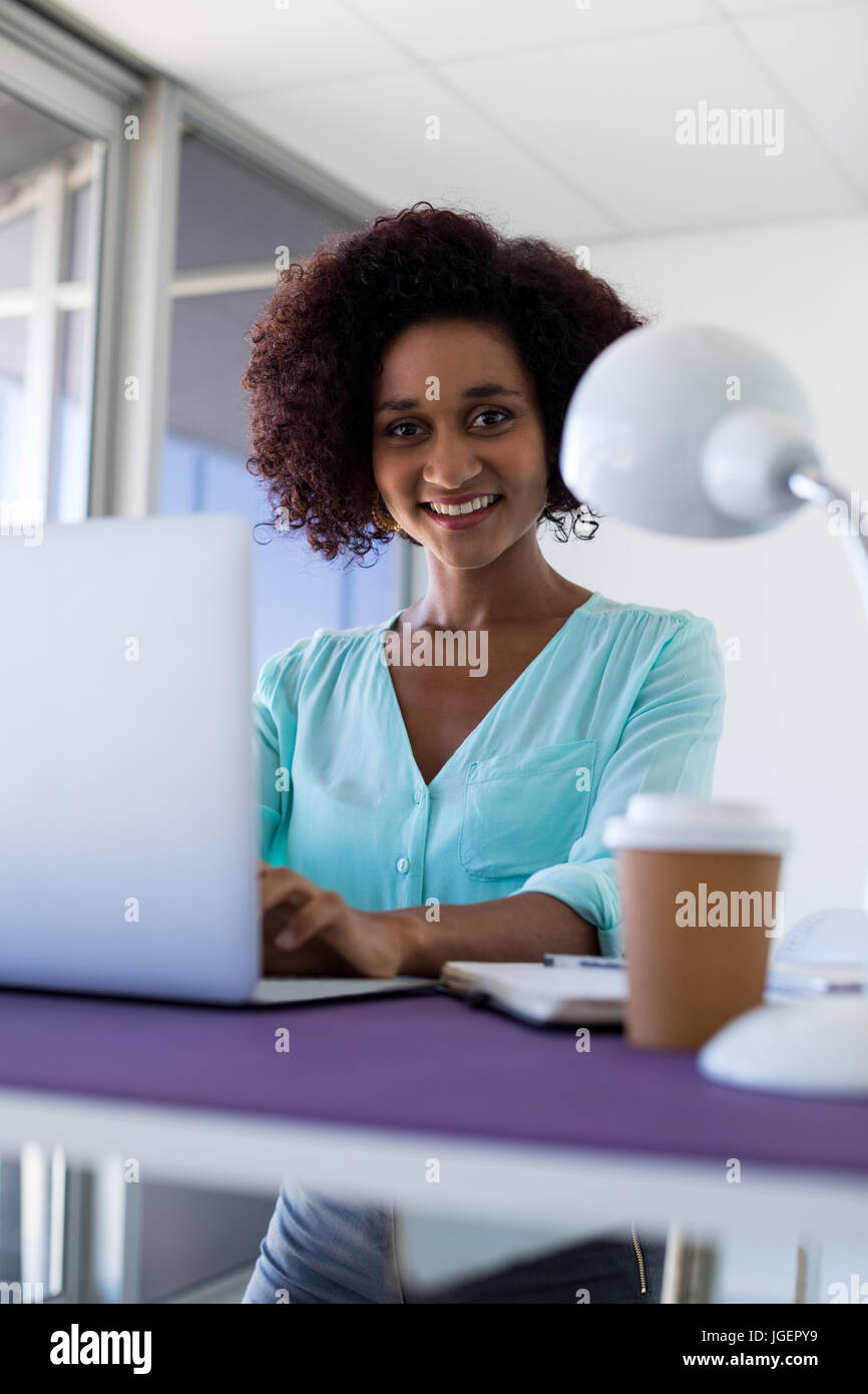Female executive working over laptop in office Stock Photo - Alamy