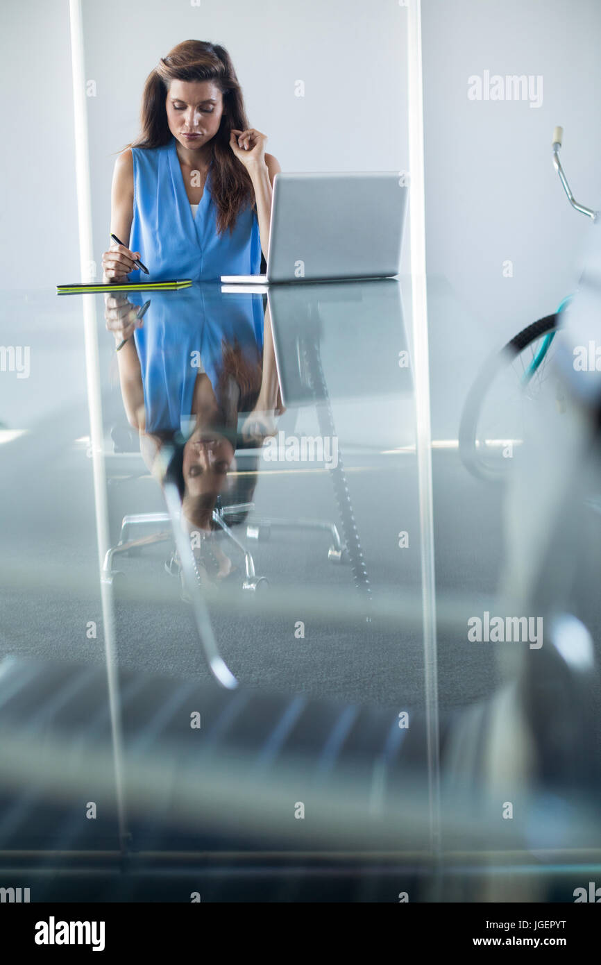 Female executive using graphic tablet and laptop in office Stock Photo ...