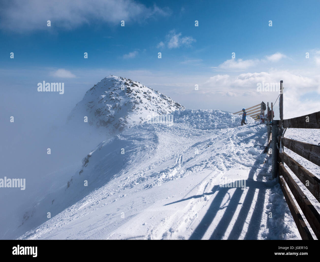 Chopok peak on snowy winter time, above the clouds with plank fence and ...