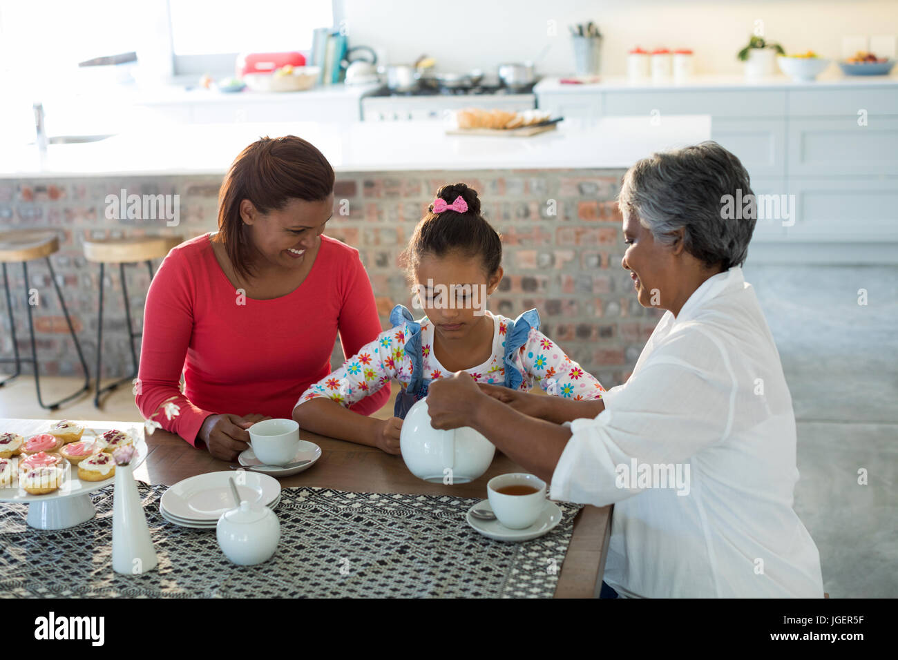 Happy multi-generation family having tea in dining table at home Stock ...