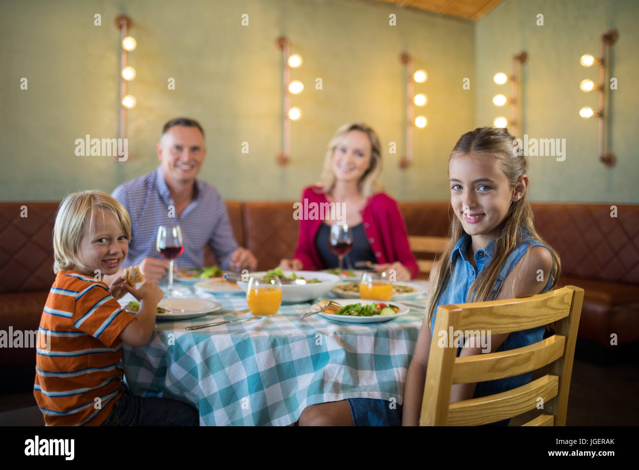Portrait of happy family dining in restaurant Stock Photo - Alamy