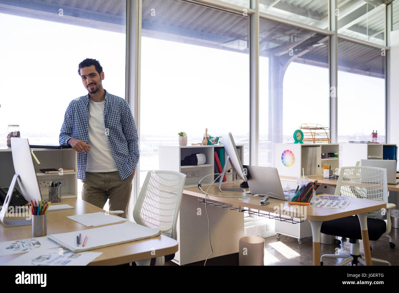 Portrait of male executive standing at his desk in office Stock Photo ...