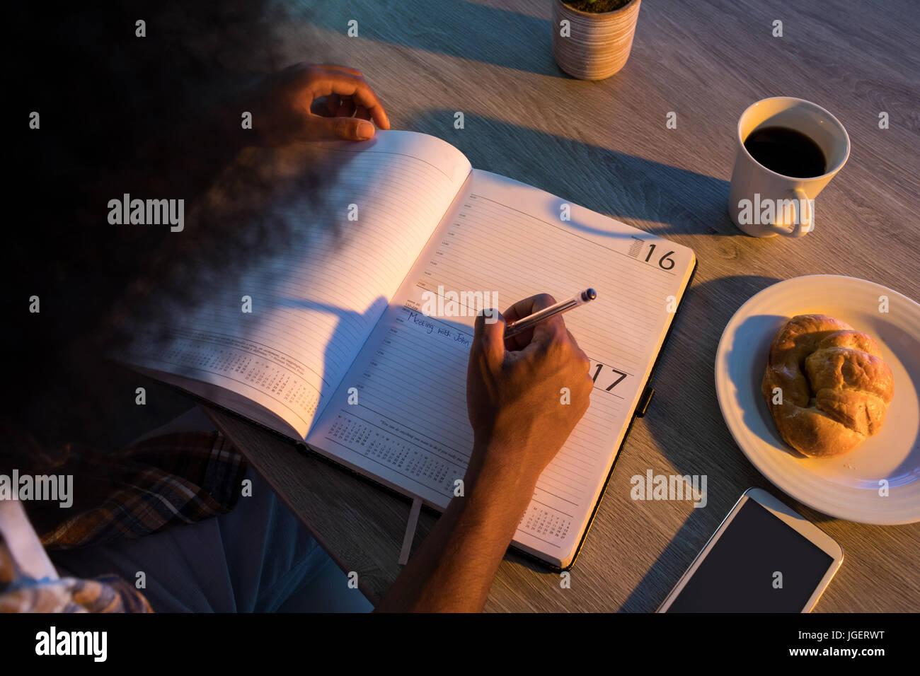 Male executive writing in diary at his desk in office Stock Photo - Alamy