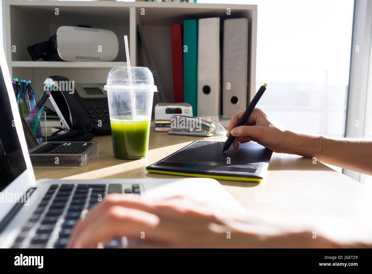 Close-up of executive using graphic tablet and laptop in office Stock ...