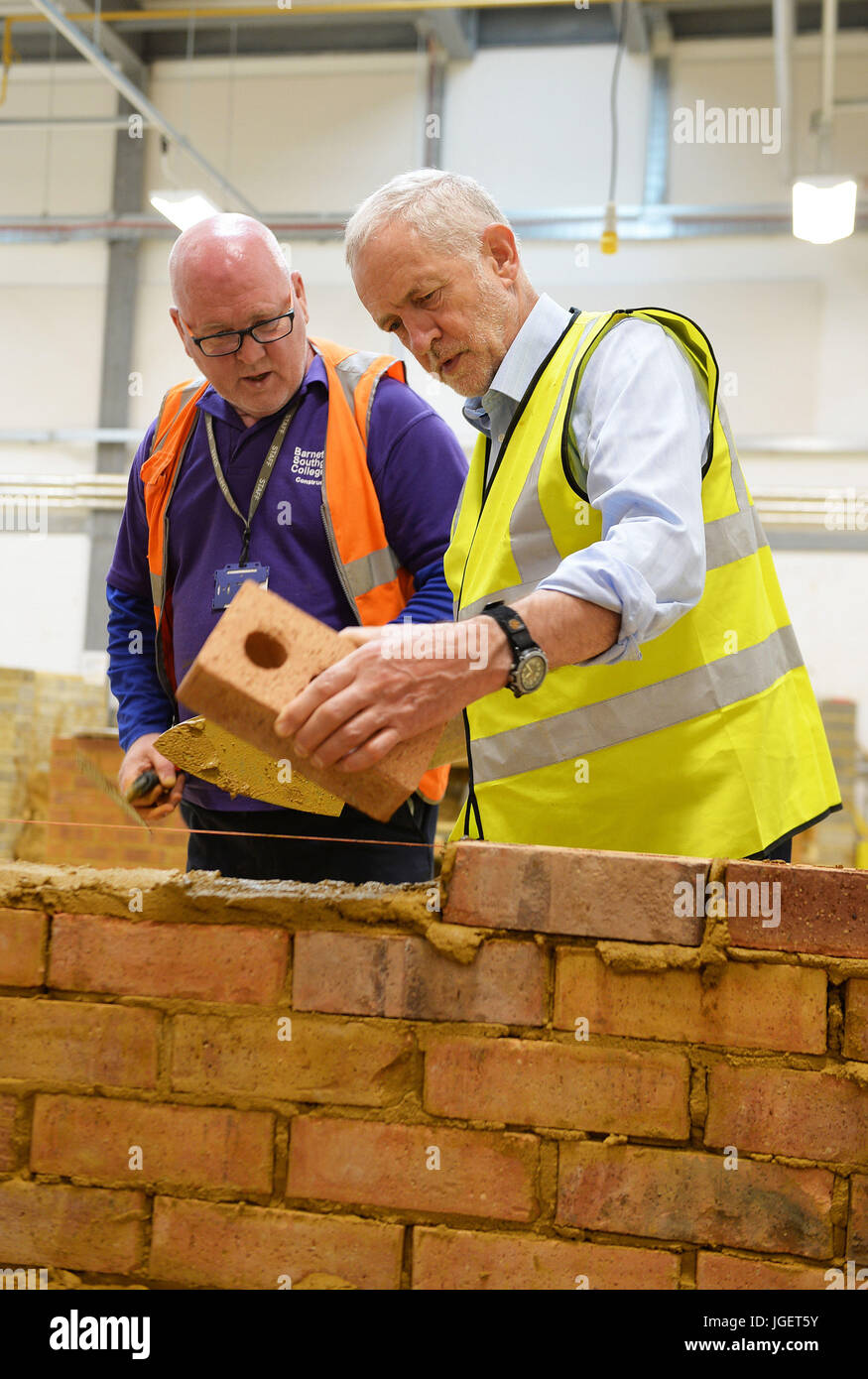Labour leader Jeremy Corbyn tries his hand at bricklaying during a ...
