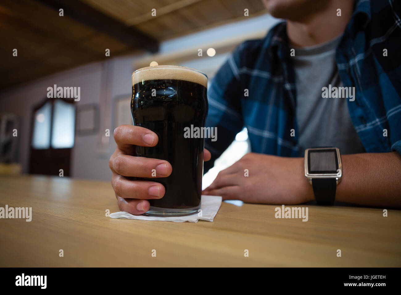 Midsection of customer with beer glass at bar counter Stock Photo - Alamy