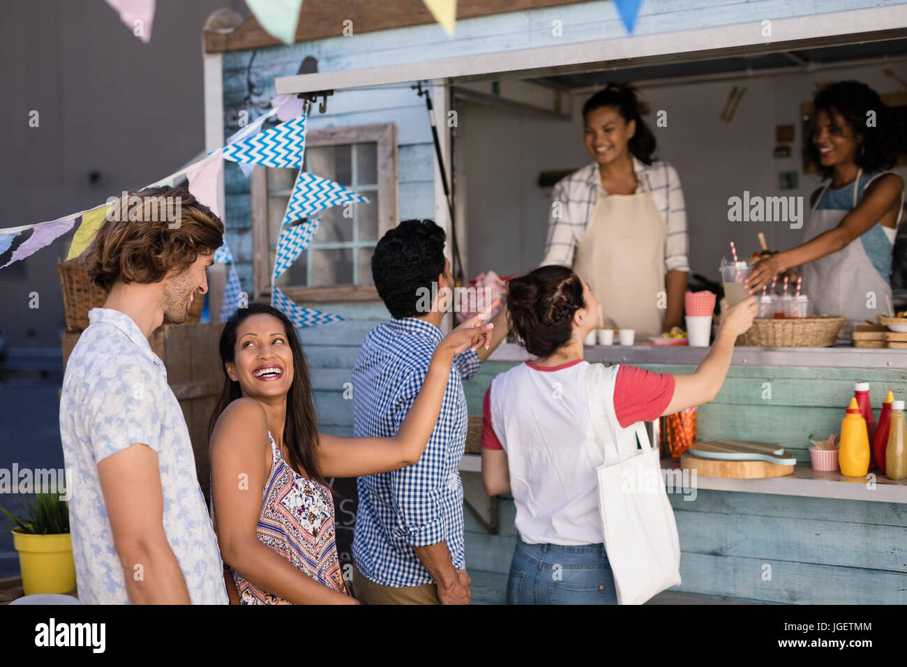 Smiling waitress giving juice to customer at counter Stock Photo - Alamy