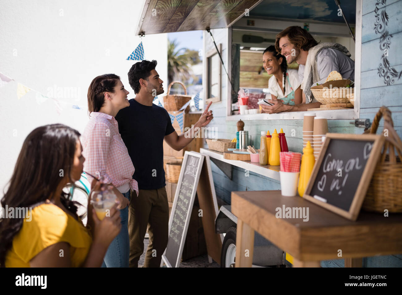 Smiling waiter taking order from couple at counter Stock Photo - Alamy