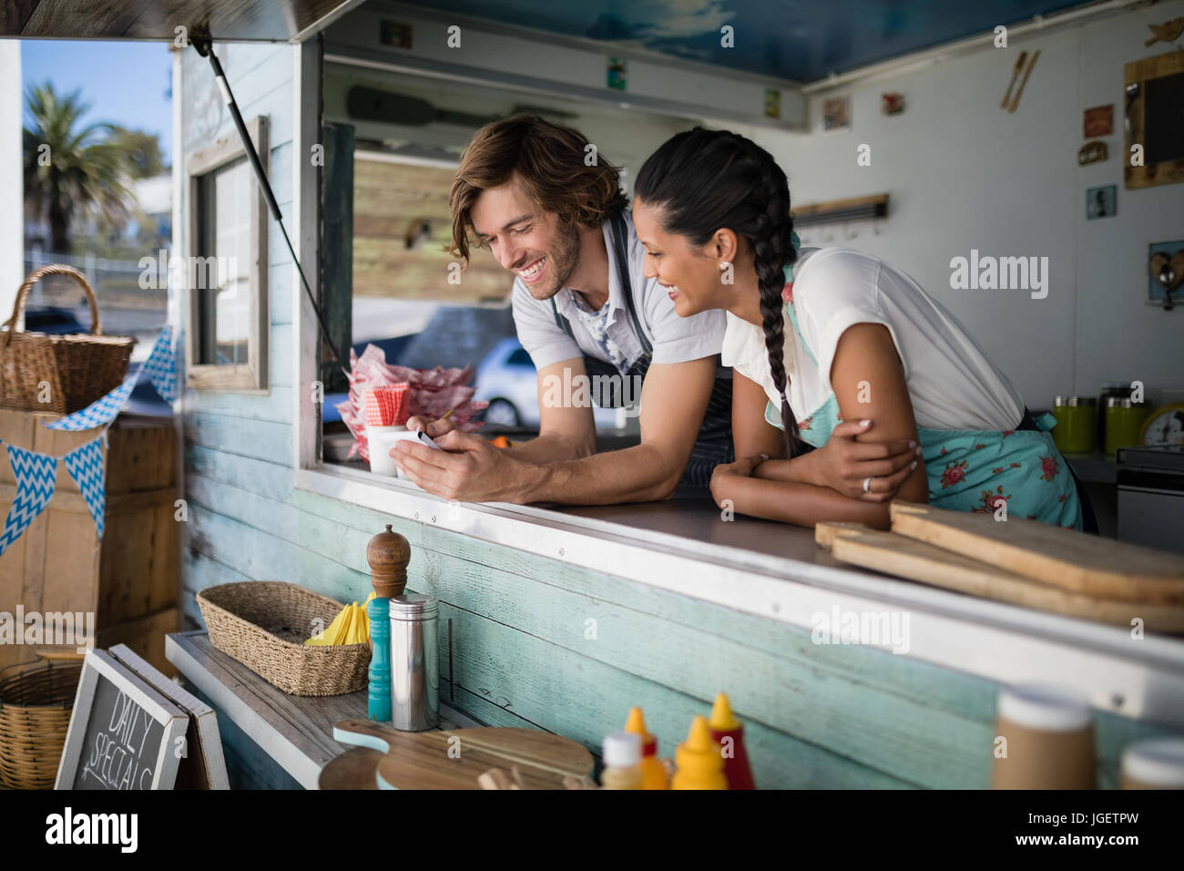 Waiter and waitress interacting with each other at counter Stock Photo ...