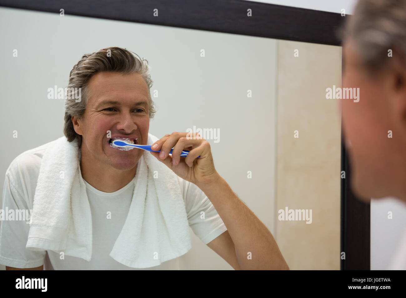 Mature man brushing his teeth in bathroom Stock Photo - Alamy