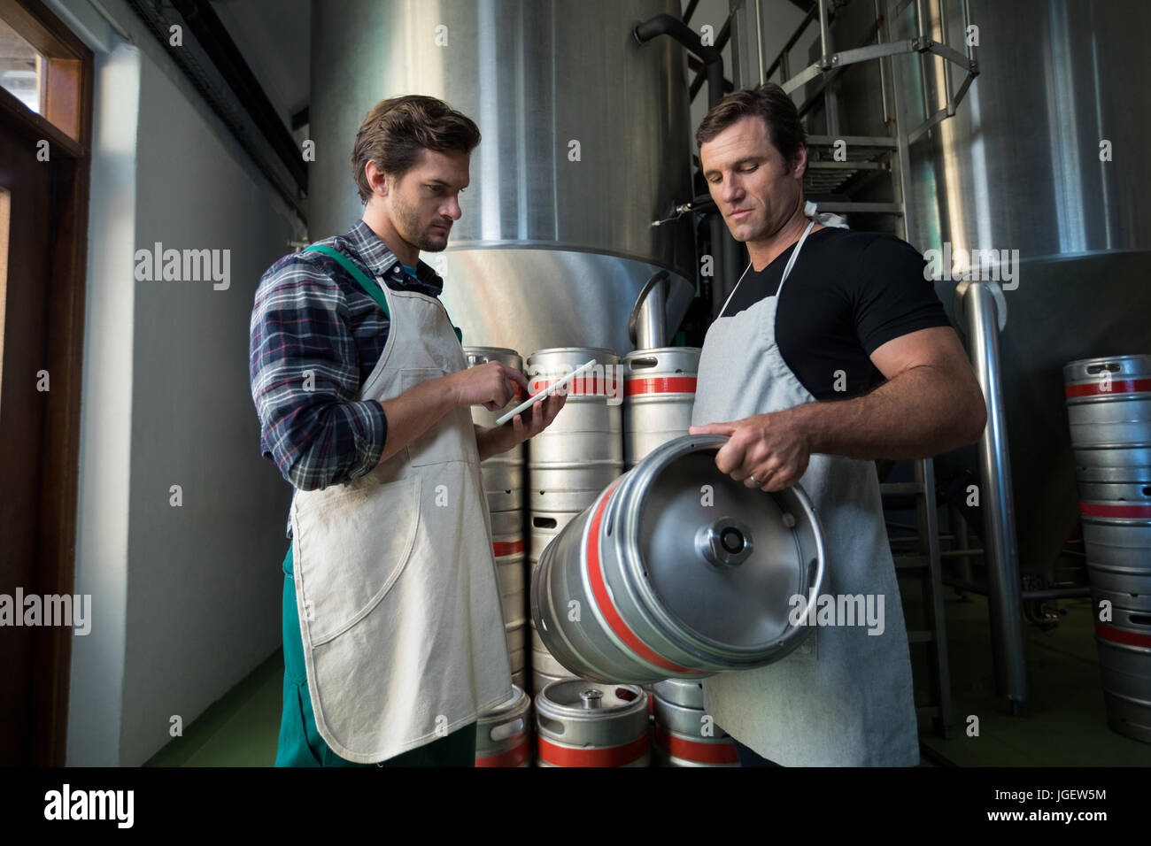Workers examining kegs at warehouse Stock Photo - Alamy