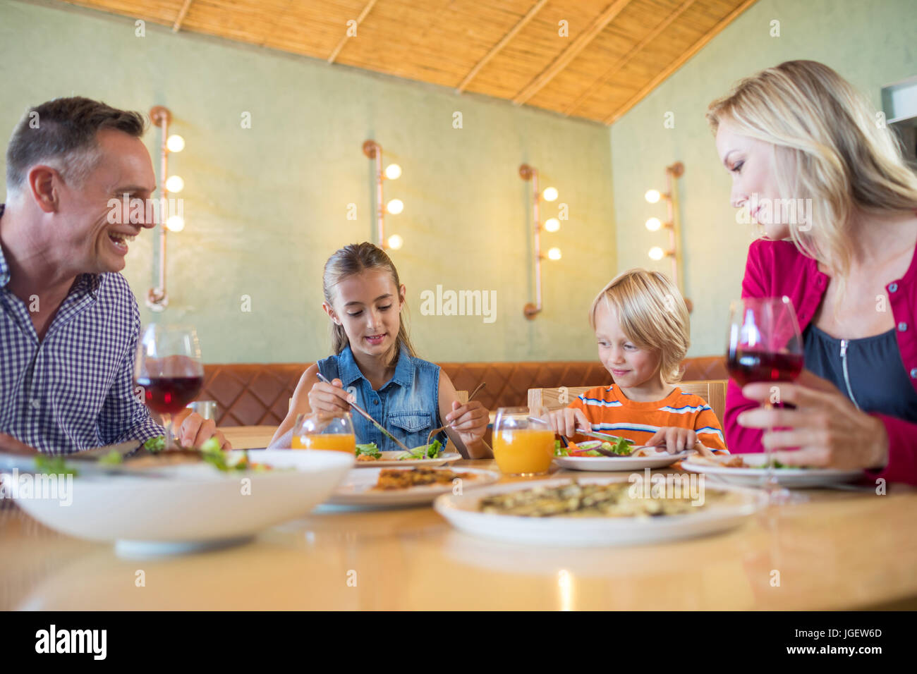 Family talking while having dinner at restaurant Stock Photo - Alamy