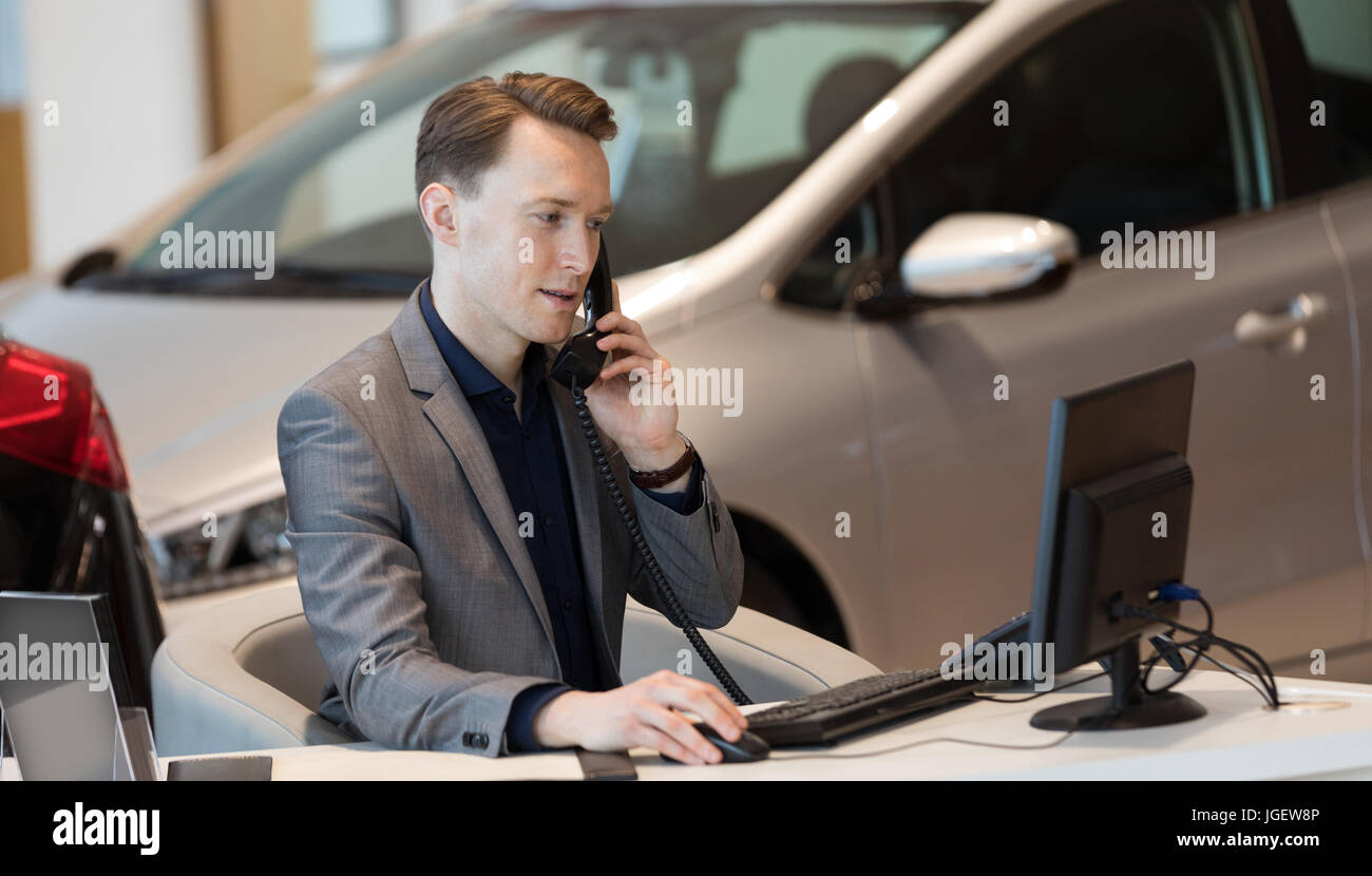 Sales talking on phone while using computer Stock Photo - Alamy