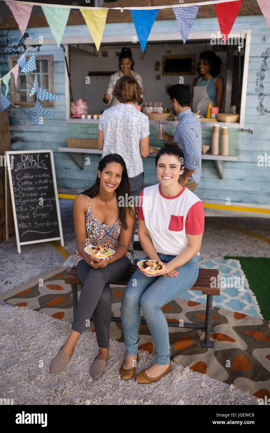 Portrait of smiling friends sitting with snacks Stock Photo - Alamy