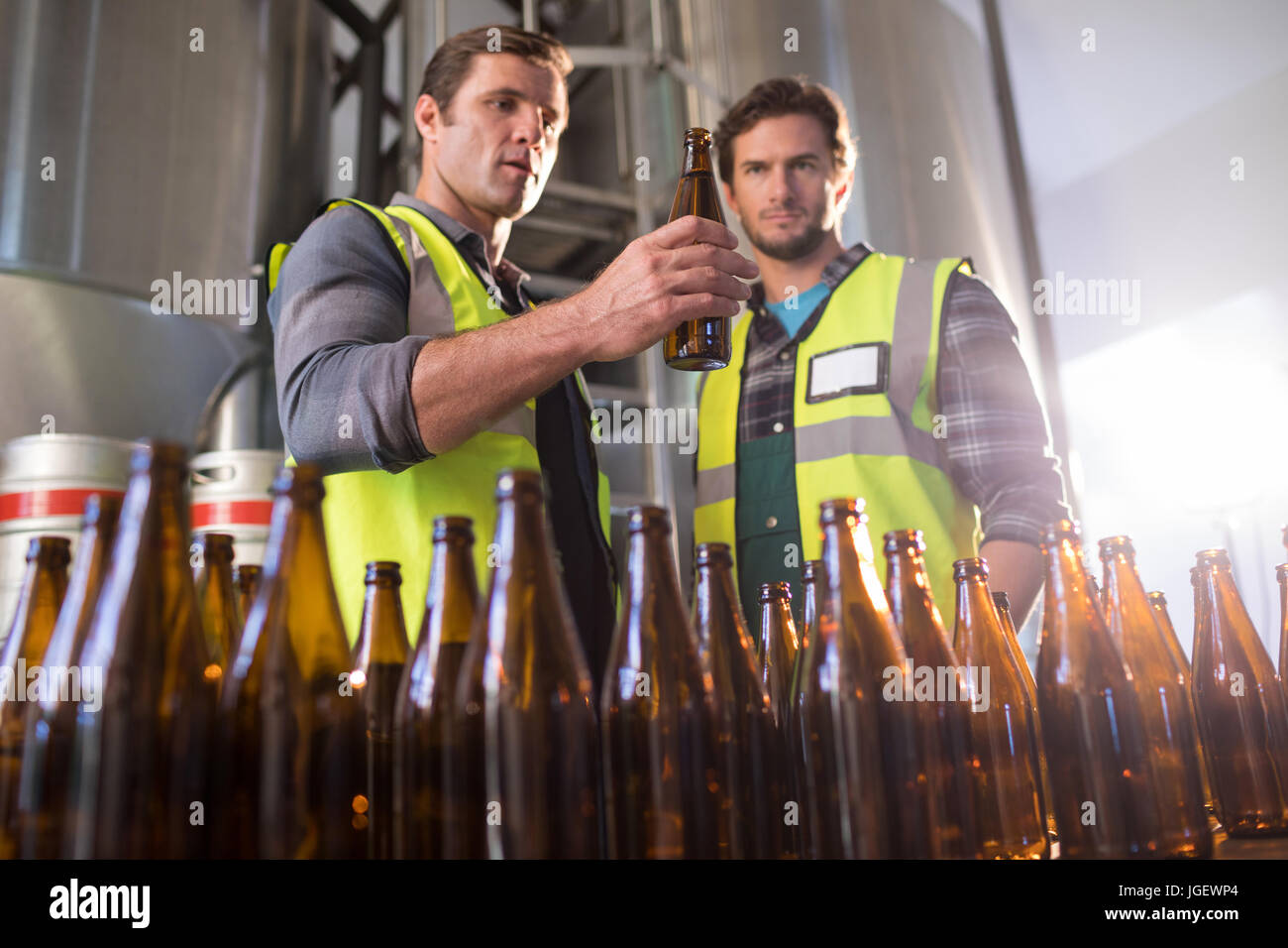 Coworkers examining beer bottles at factory Stock Photo - Alamy