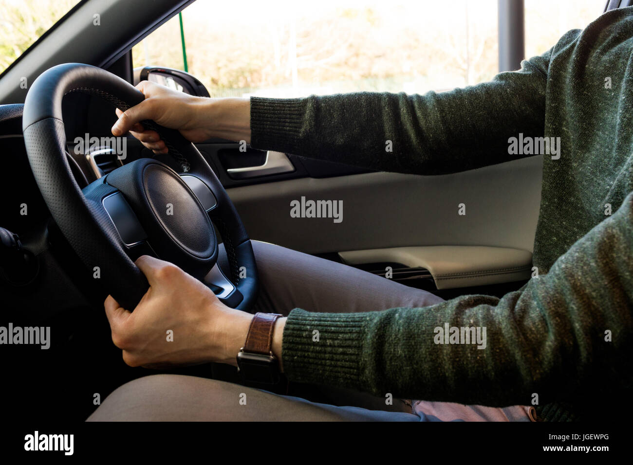 Midsection of man test driving in car Stock Photo - Alamy