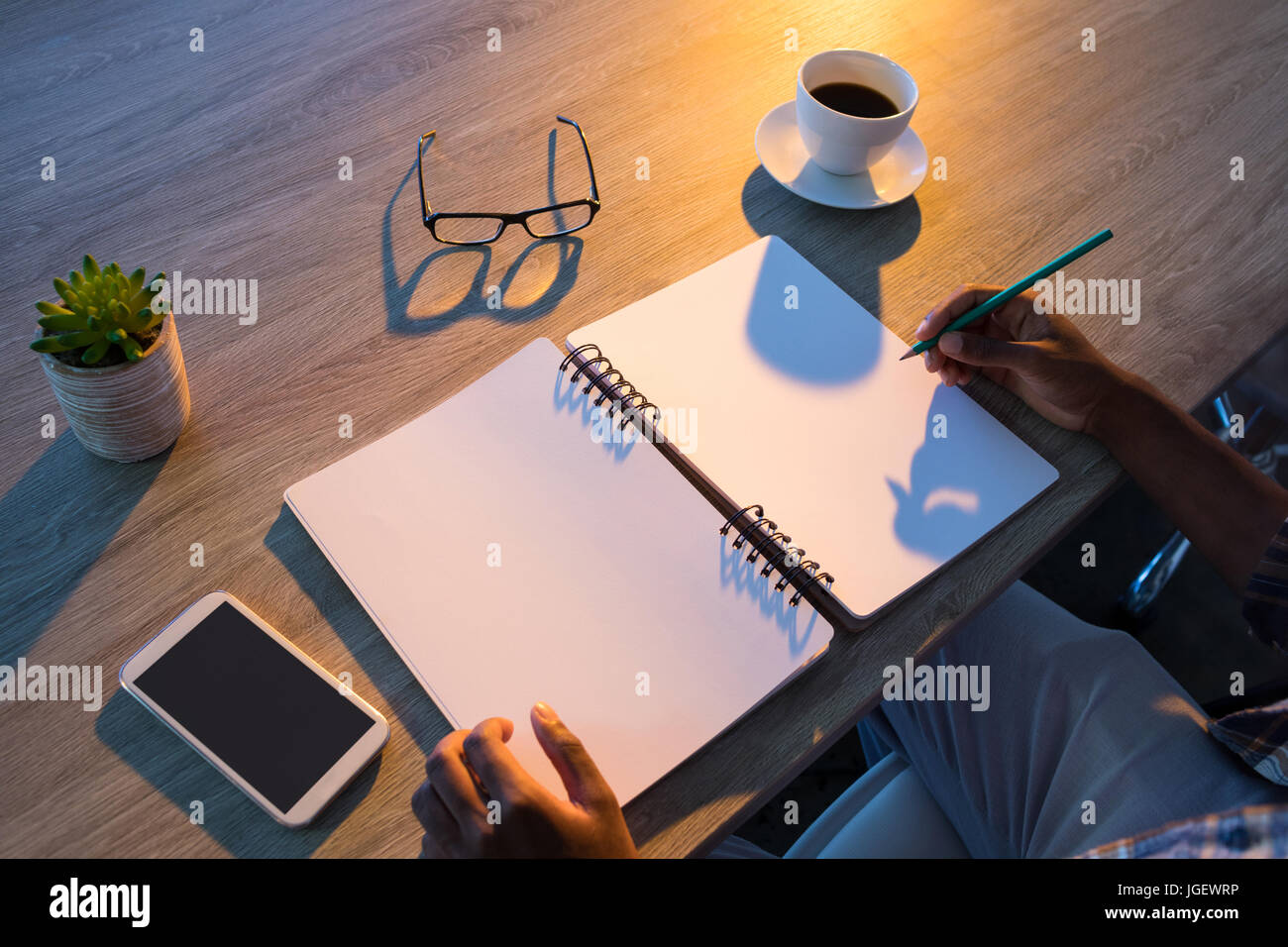 Male executive writing in diary at his desk in office Stock Photo - Alamy
