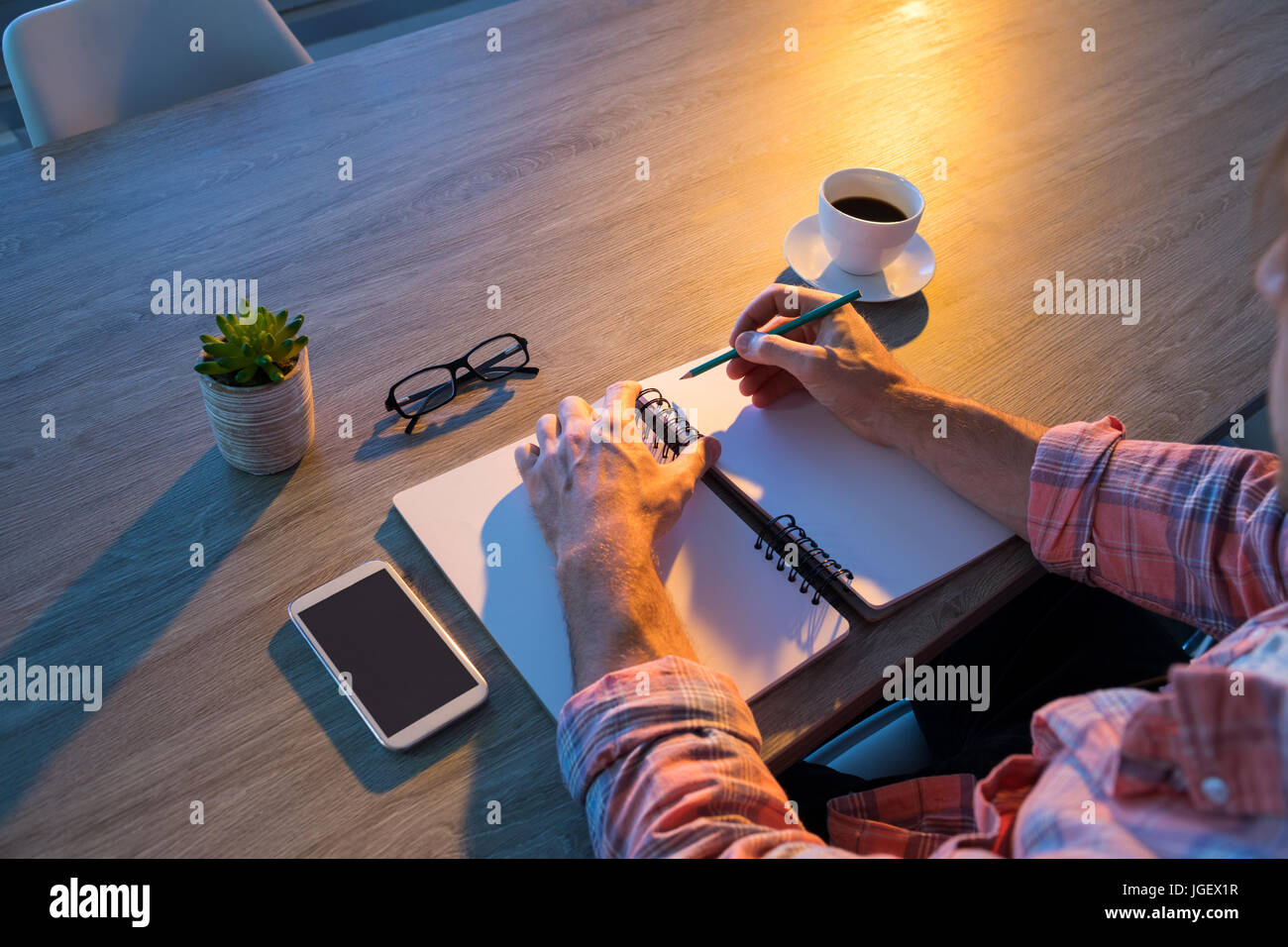 Male executive writing in diary at his desk in office Stock Photo - Alamy
