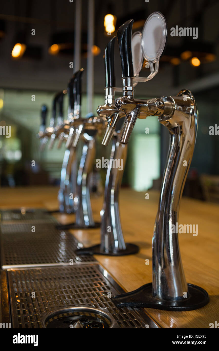 Beer taps in row at restaurant counter Stock Photo - Alamy