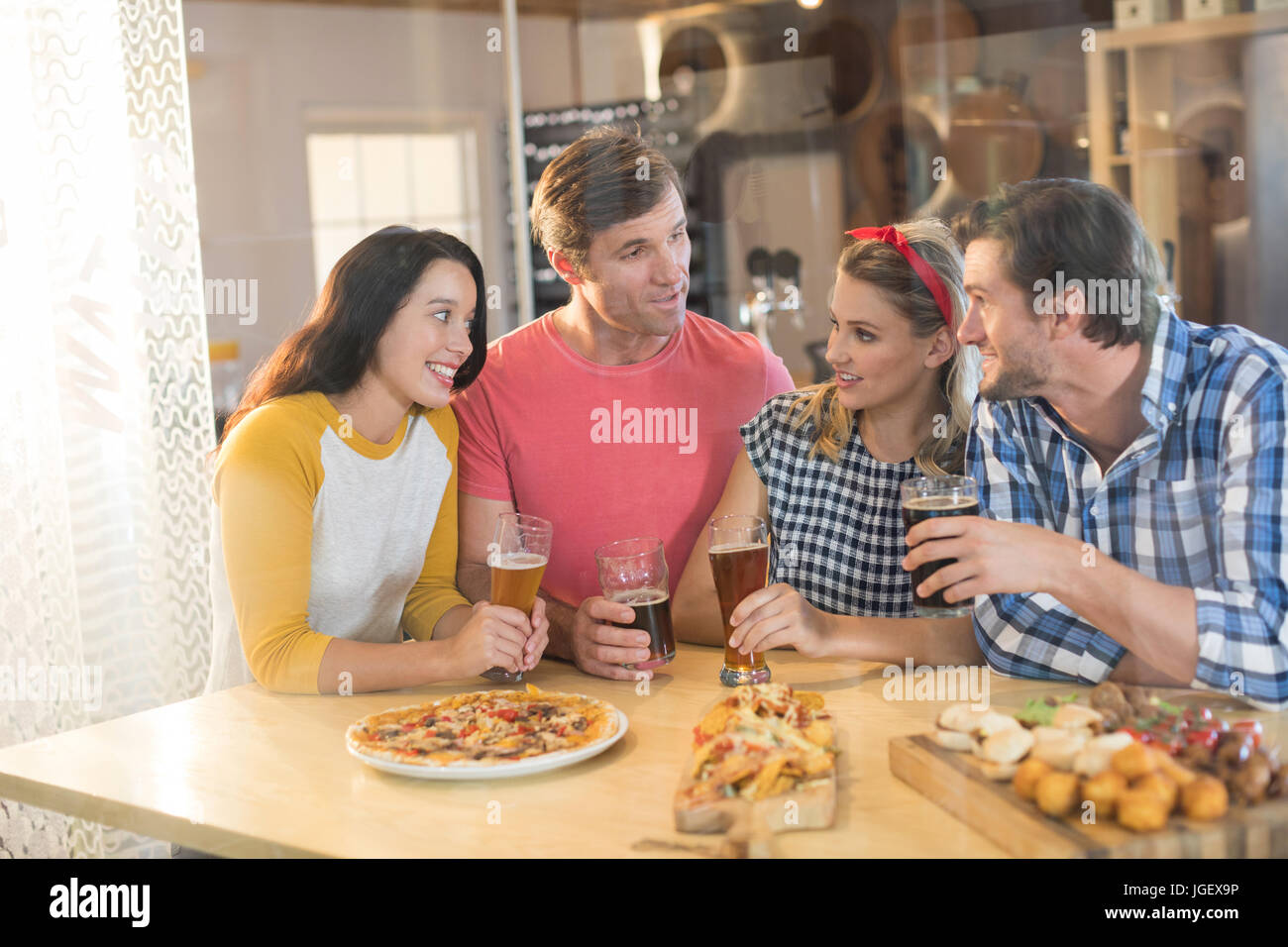 Friends talking while having beer at table in restaurant Stock Photo ...