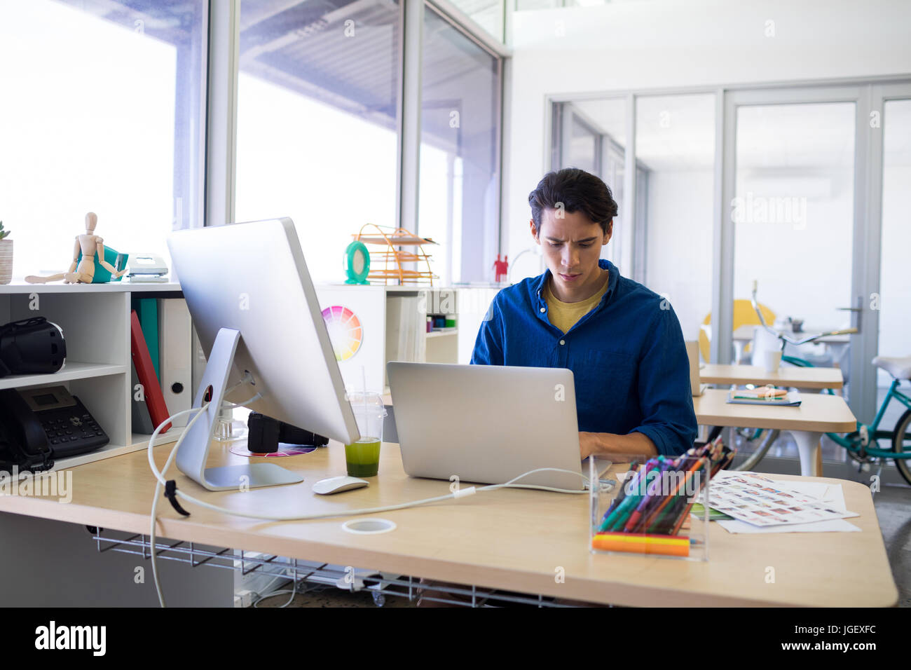 Male executive working over laptop at his desk in office Stock Photo ...