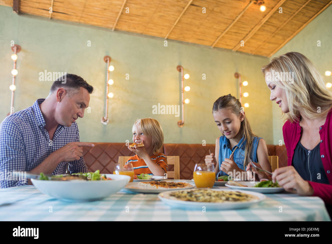 Smiling family having food at restaurant Stock Photo - Alamy